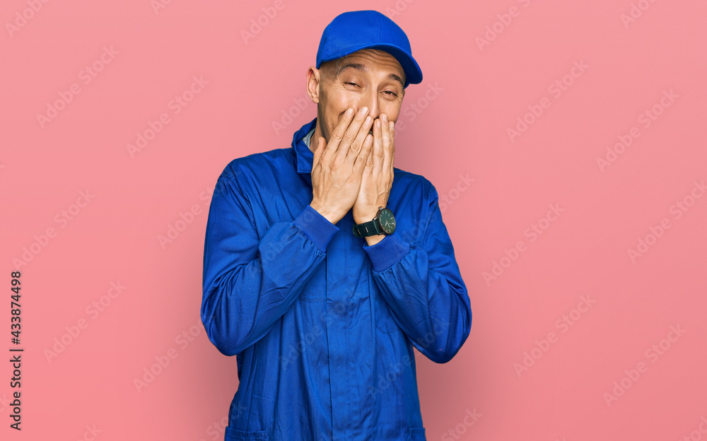 Bald man with beard wearing builder jumpsuit uniform laughing and ...