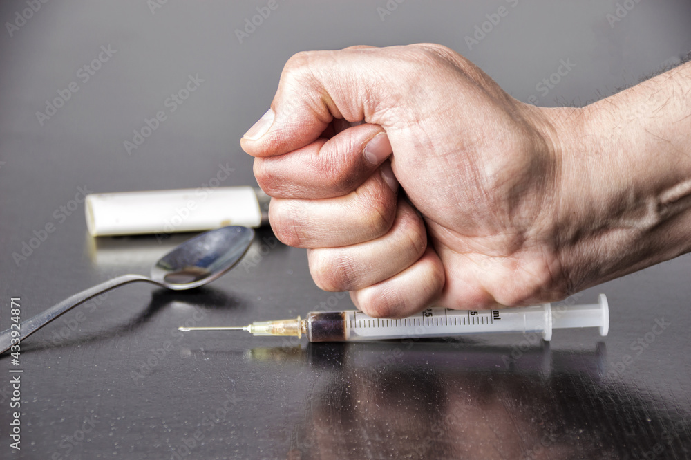 Stop drug addiction concept. Young hand crushing erotic geringa with ...