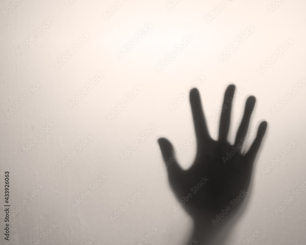 shadow human hand or people palm on window frosted glass or sepia door ...