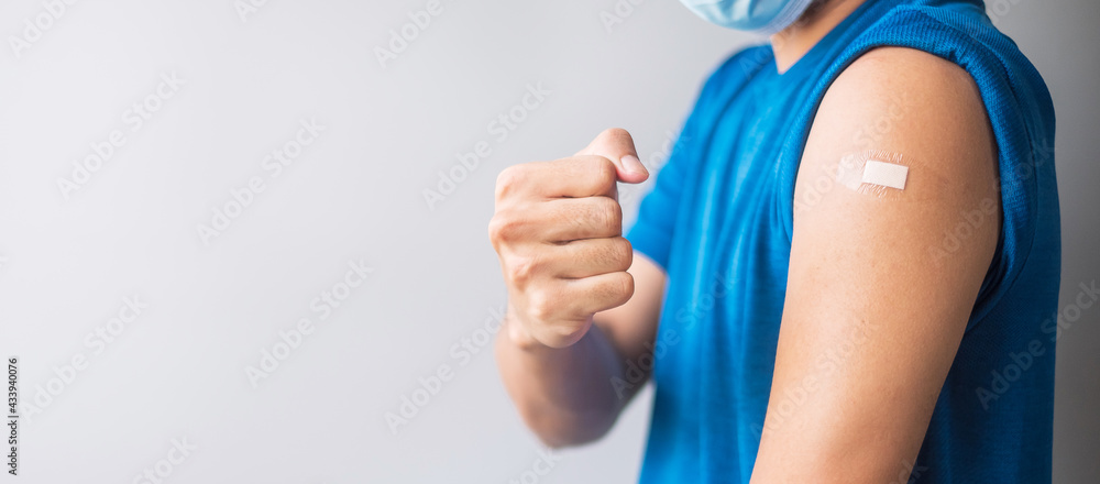 Happy man showing his arm with bandage after receiving vaccine ...