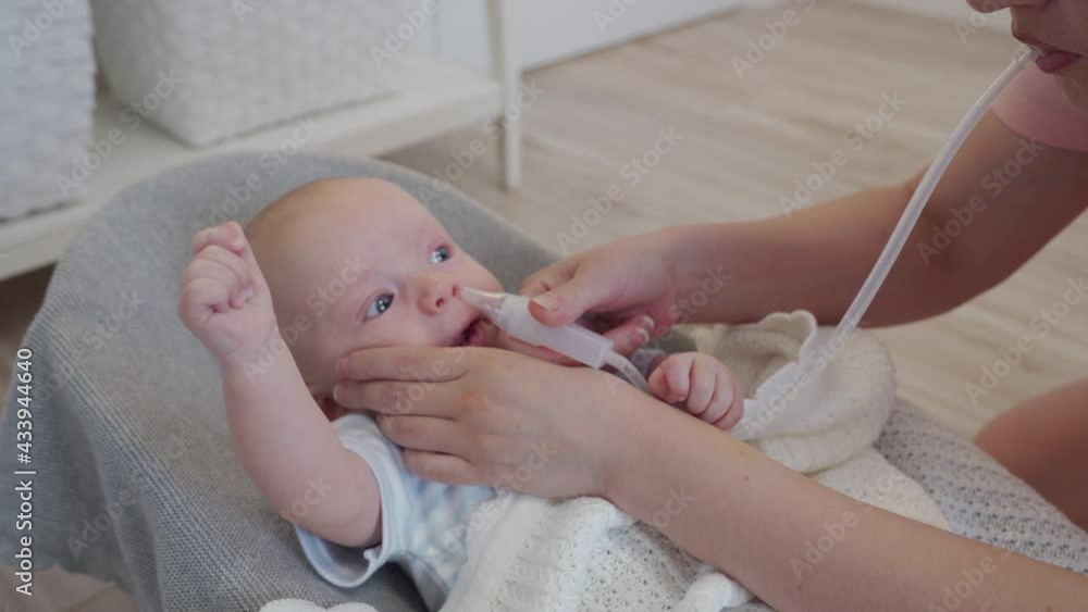 Vidéo Stock Suctioning child stuffy nose with a bulb syringe, mother ...