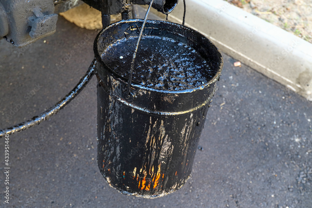 Road works for laying asphalt. Full bucket of bitumen Stock Photo ...