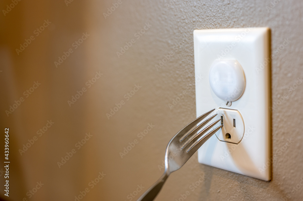 Selective focus on edge of a metal fork about to be inserted into an ...