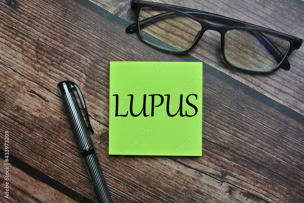 Selective focus of spectacle, pen and sticky note written with LUPUS ...