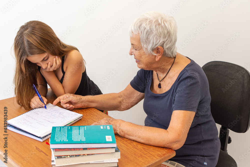 Pessoa idosa ensinando menina tarefas escolares Stock Photo | Adobe Stock