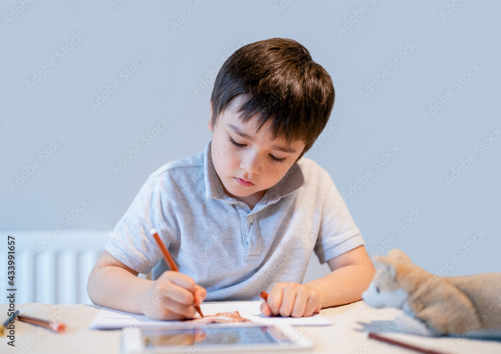 School Kid using colour pen drawing and painting on paper, A boy doing ...
