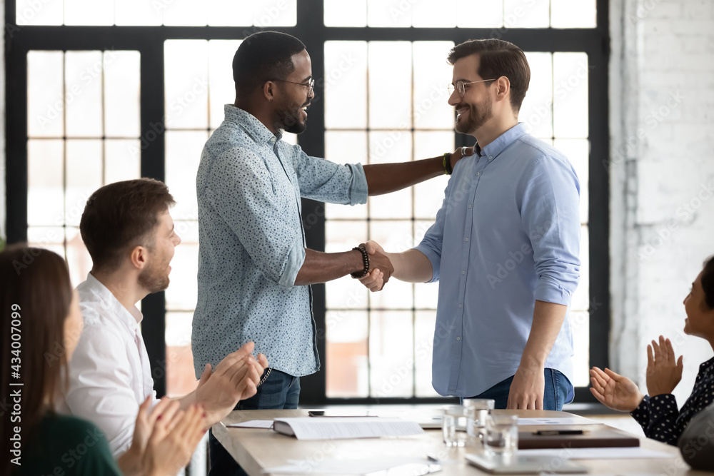 Happy African American male boss welcoming new hired employee, team ...