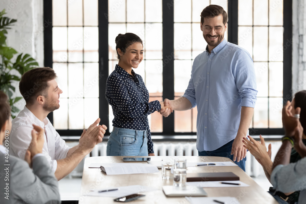 Happy Indian female team leader shaking hands with proud employee ...