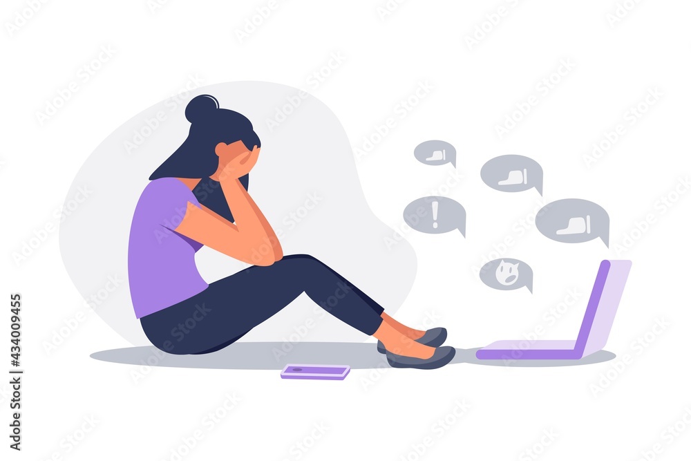 Sad woman sitting and crying with phone in front of laptop screen ...