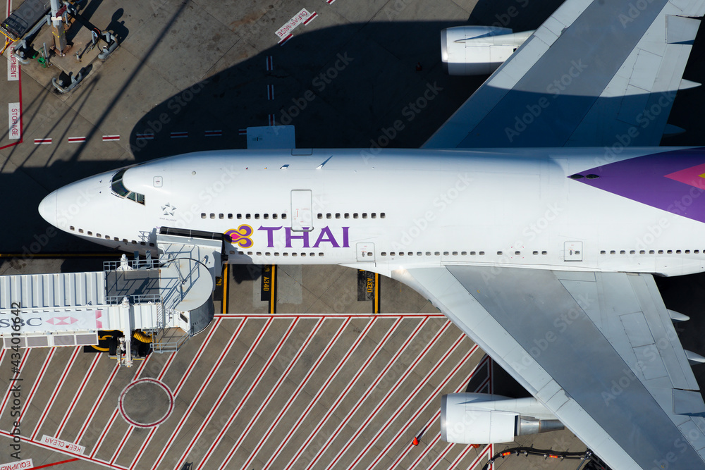 Thai Airways International Boeing 747 parked at a gate with jet bridge ...