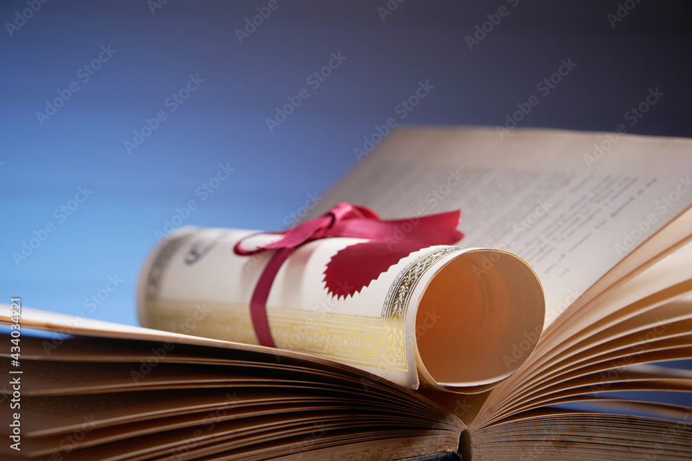 scroll of certificate on open book Stock Photo | Adobe Stock