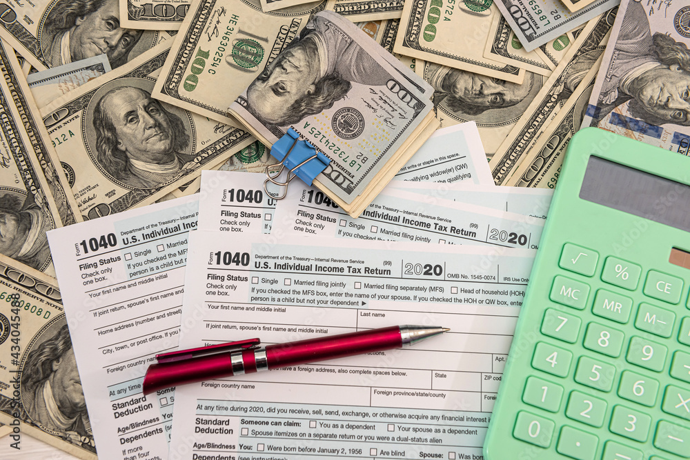 tax forms 1040 with dollars and calculator for filling in April Stock ...
