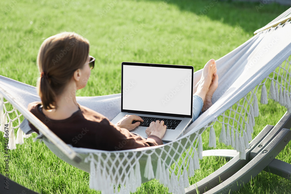 Young woman using laptop outdoor. Young beautiful girl sitting in a ...
