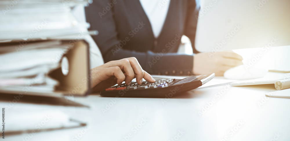 Accountant checking financial statement or counting by calculator ...