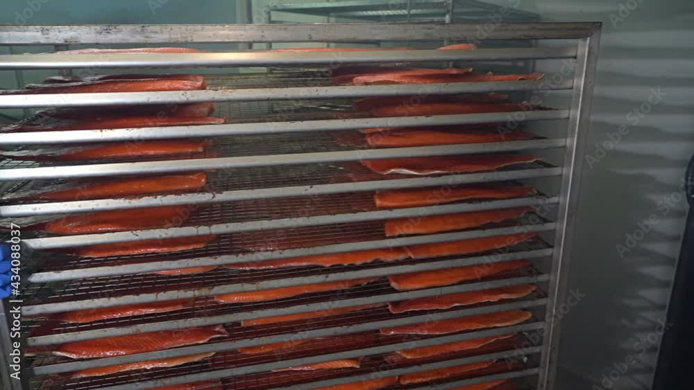 Fish industry worker handling trolley filled with salmon inside a ...