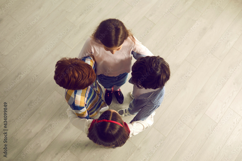 High angle group shot of elementary school children huddling in tight ...