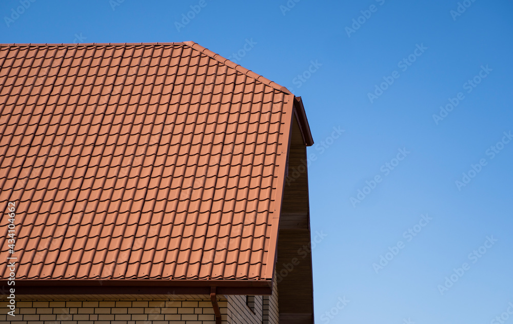 Red corrugated metal profile roof installed on a modern house. The roof ...
