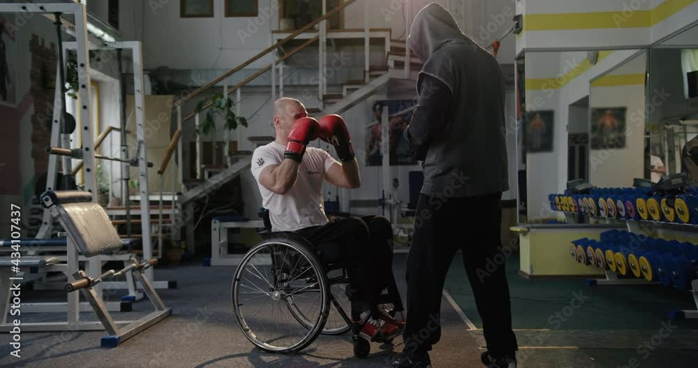 Boxing with a coach in boxing gloves is exhausting Training in the gym ...