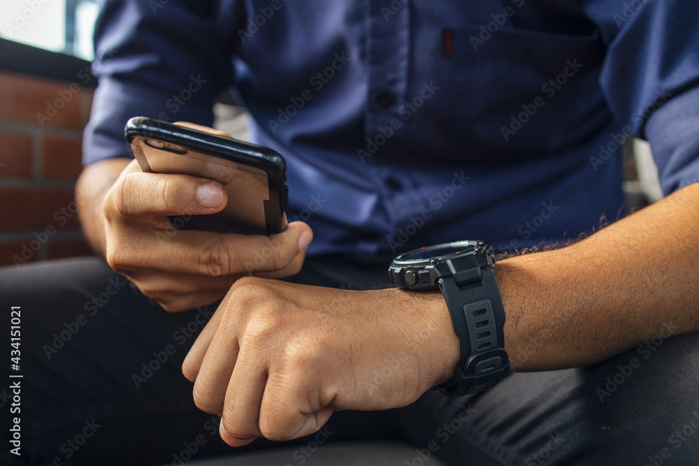 businessman wearing digital smart watch in hand touching screen to open ...