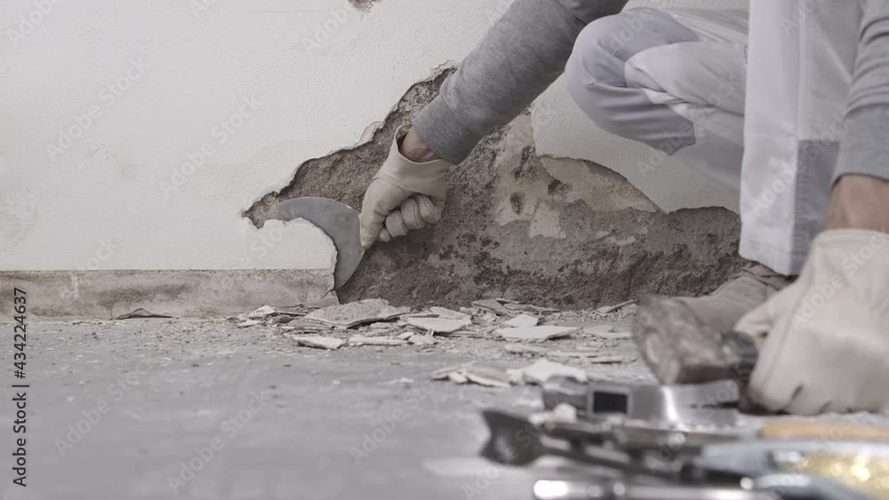 Construction worker hands with gloves working with spatula scrape off ...