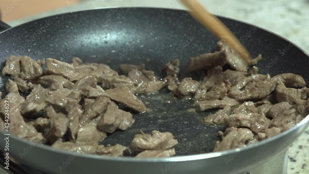 Cooking raw beef in a black pan, close up Stock Video | Adobe Stock