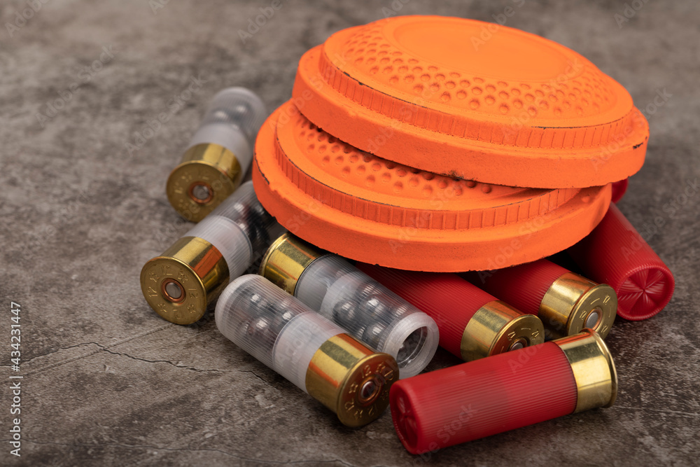 Clay disc flying targets and shotgun shells on texture background ,Clay ...