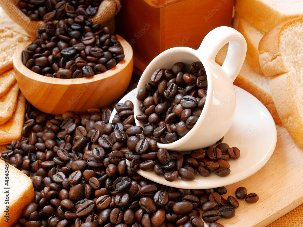 Foto de Cup of coofee beans is near wooden bowl of coffee beans and ...