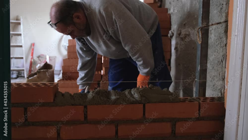 Construction worker building a brick wall. Man bricklaying. Mason ...