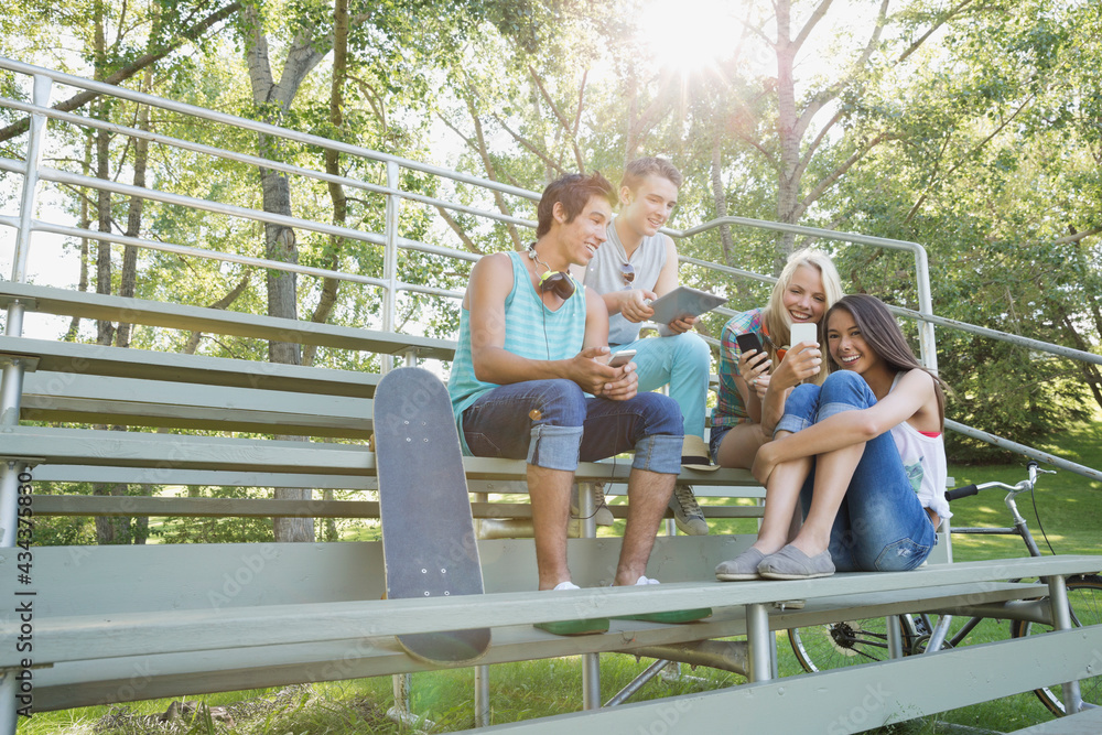 Teens using smart devices outdoors Stock Photo | Adobe Stock