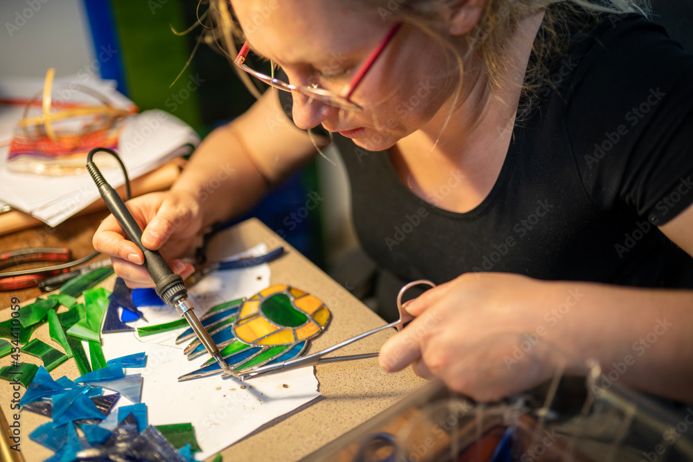 Poster soldering the stained glass window, woman is making a stained ...