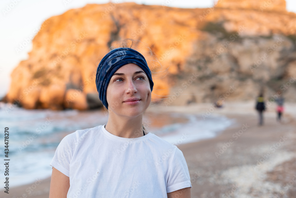 Poster A young girl with a dimple on her cheek stands by the sea and ...