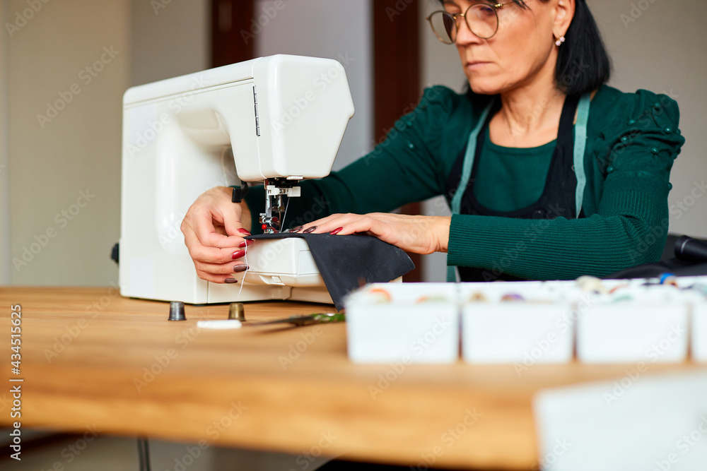 Step by step, 50-yers old woman sews clothes on sewing machine Stock ...