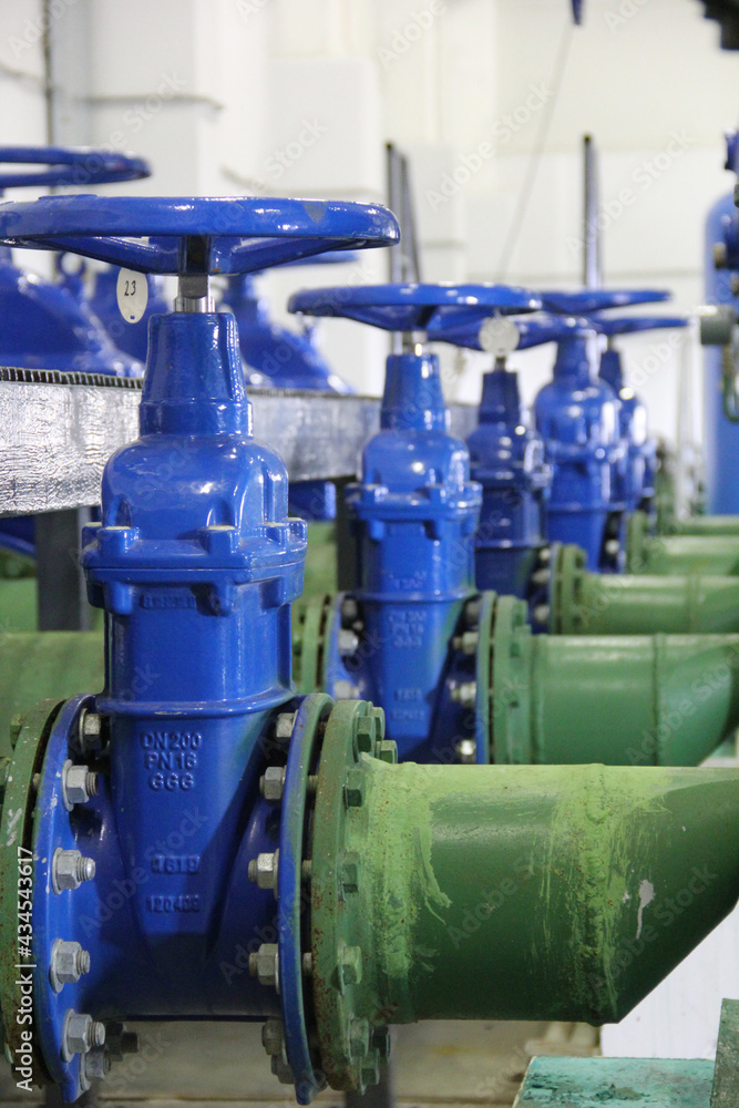 huge blue valves on the green pipes of the water station Stock Photo ...