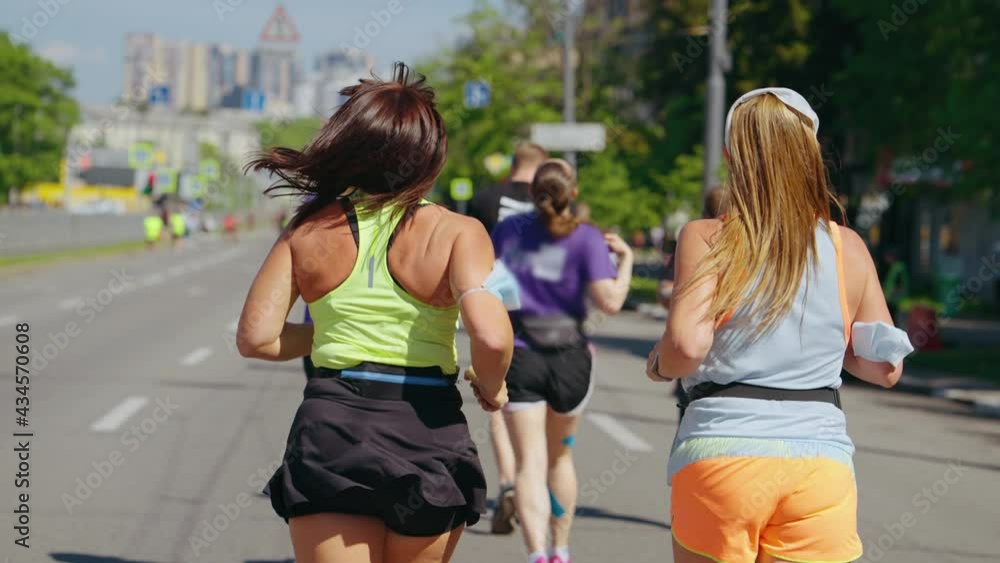 Vidéo Stock Slow motion women with curvy forms wearing sportswear running marathon, other ...
