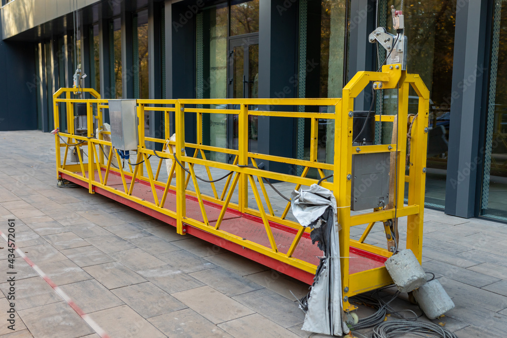 Suspended construction cradle after glazing the facade of a commercial ...