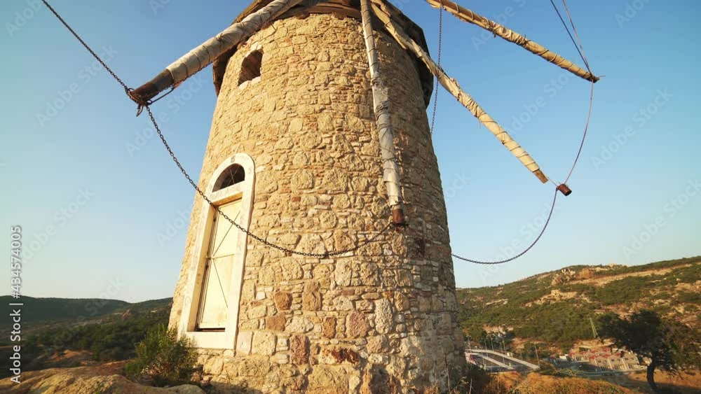 Old traditional historic windmill by the sea at the sunset.Wind power ...