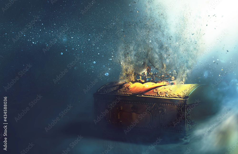 low key image of beautiful queen or king crown over gold treasure chest ...