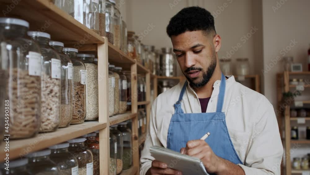 Male owner of zero waste shop doing audit. Stock Video | Adobe Stock