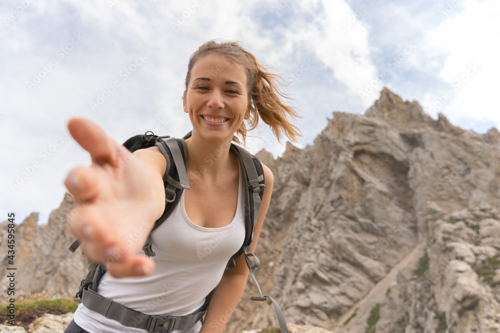 young man on top of the mountain, extending his hand to help you reach ...