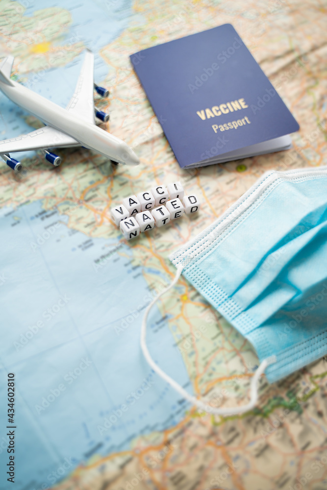 Vaccinated traveler planning booking flights and trip. Table with blue ...