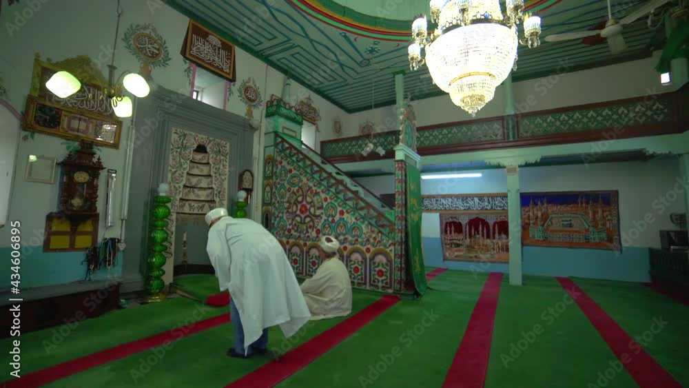 Muslim mosque teacher in a robe and turban at the small historic wooden ...