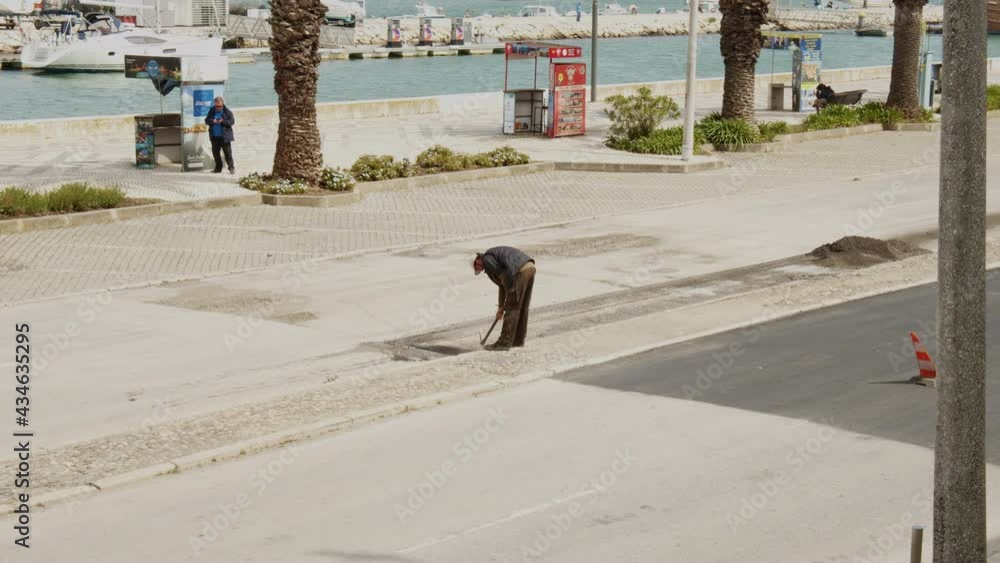 Vídeo do Stock: Elevated view of street worker using pickaxe to finish ...