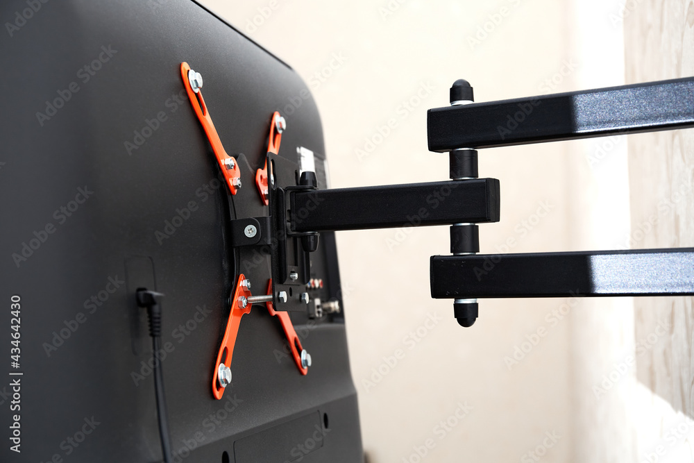 Swivel TV bracket LED display. Back view. X-shaped red fasteners. Black ...
