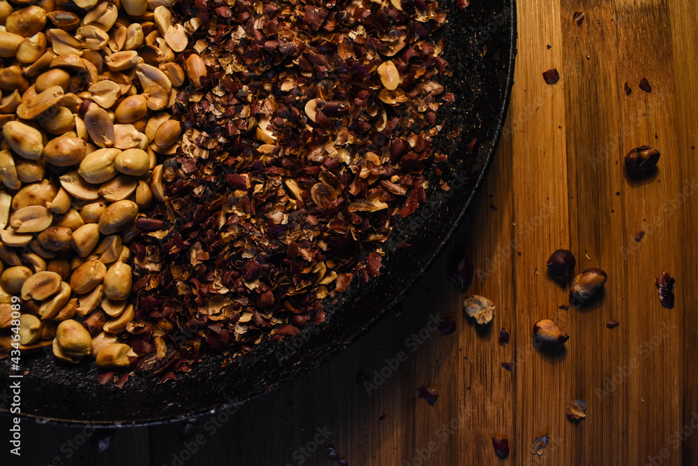 Top view of the process of peeling roasted peanuts in a traditional way ...