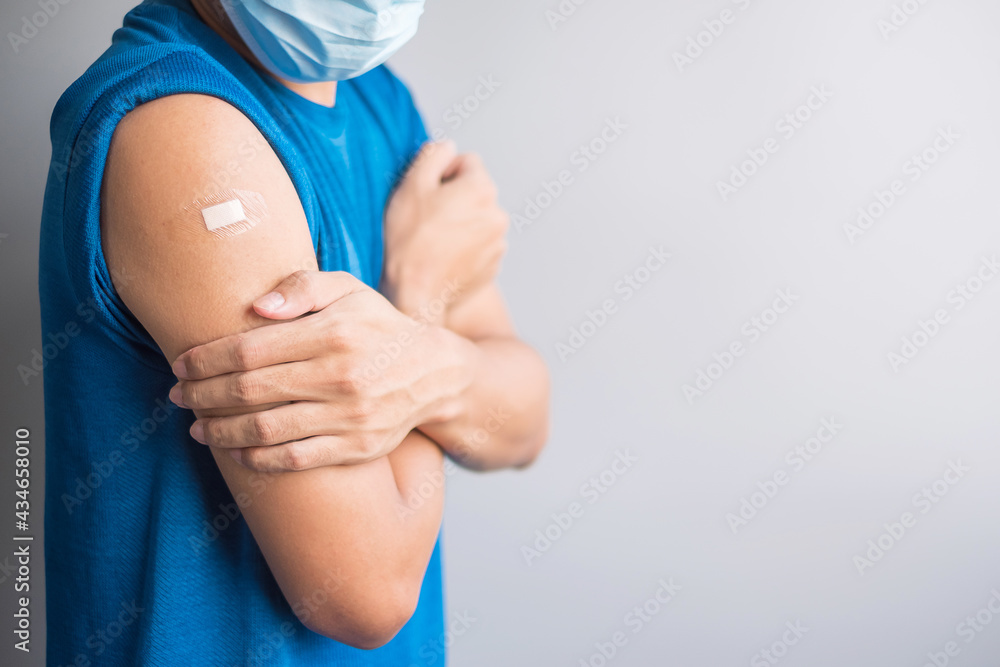 Happy man showing his arm with bandage after receiving vaccine ...