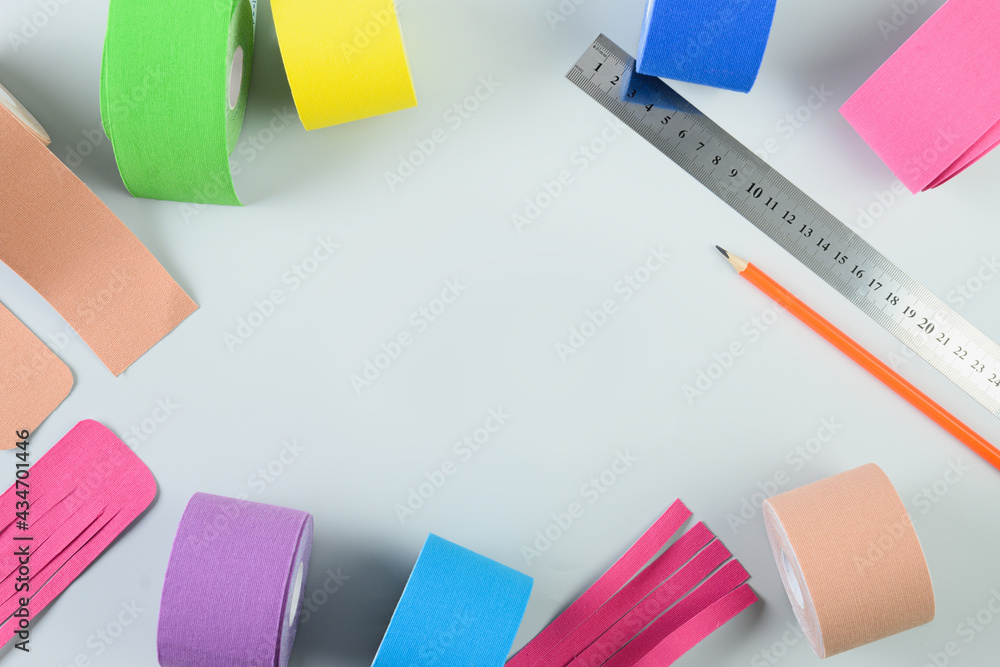 Colorful kinesiology tape, scissors, pencil, ruler and different shape ...