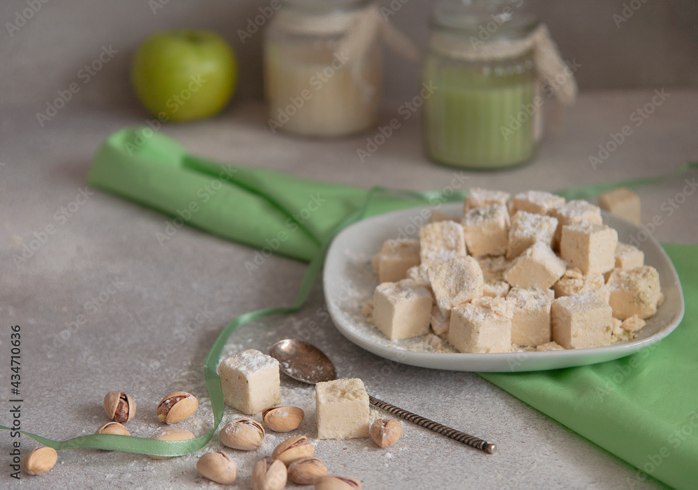 Pistachios halvah in plate with pistachios nuts with green cloth on ...