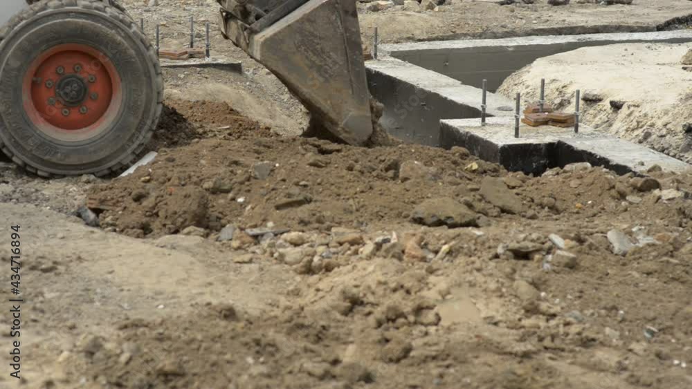 Mini excavator leveling the ground with the front bucket on the ...