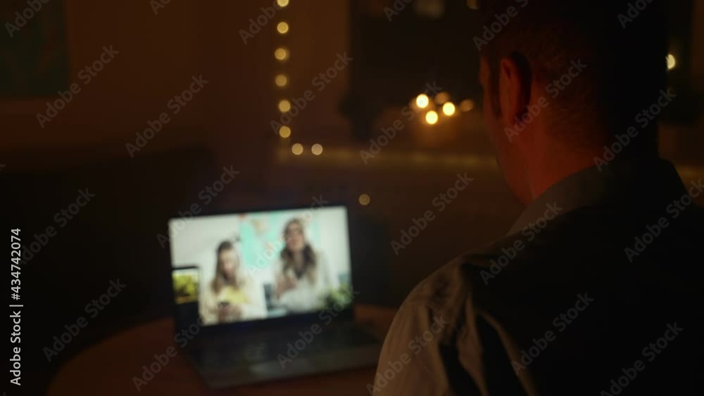 Man talking with his family in video chat at night. Time differences ...