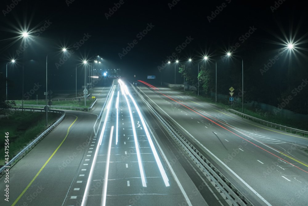 Night road with long red and white light strips from the headlights of ...